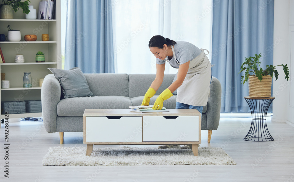 Cleaning, tidy and woman by table in living room for organising, remove dirt or doing chores ...