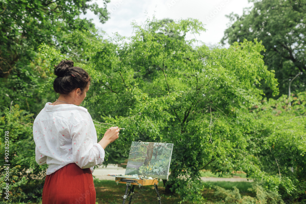 Female artis paints a picture in the park. Mindfulness, art therapy ...
