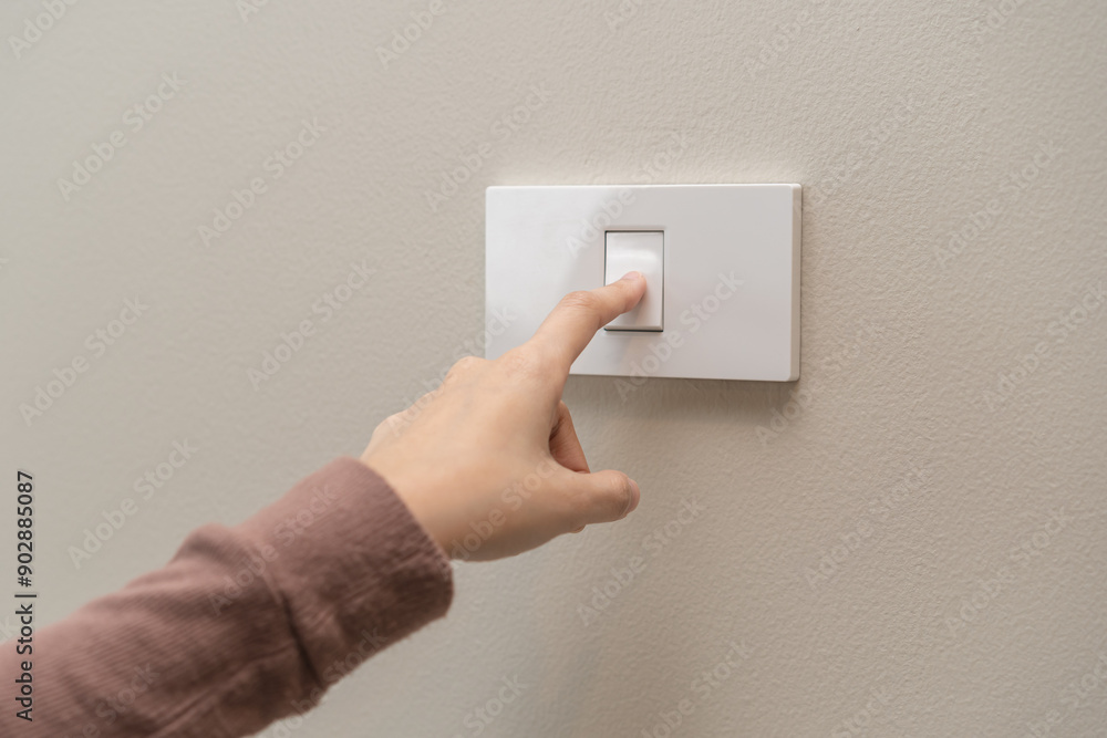 Close up of hand of woman turn off on lighting switch at home room ...