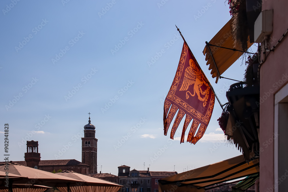 Large Venetian flag hanging from a pole in front of a building near the ...