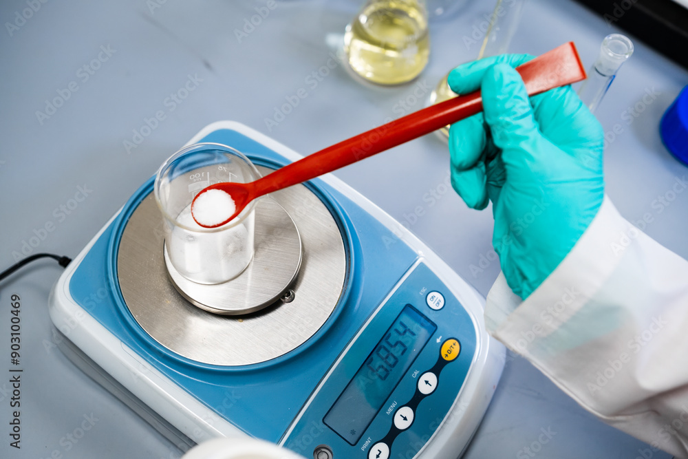 Top view woman is using laboratory balances to weigh powder samples ...