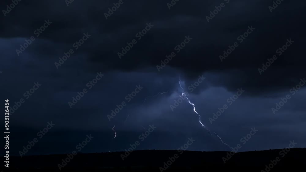 Intense lightning strikes through dark clouds, brightening the stormy ...