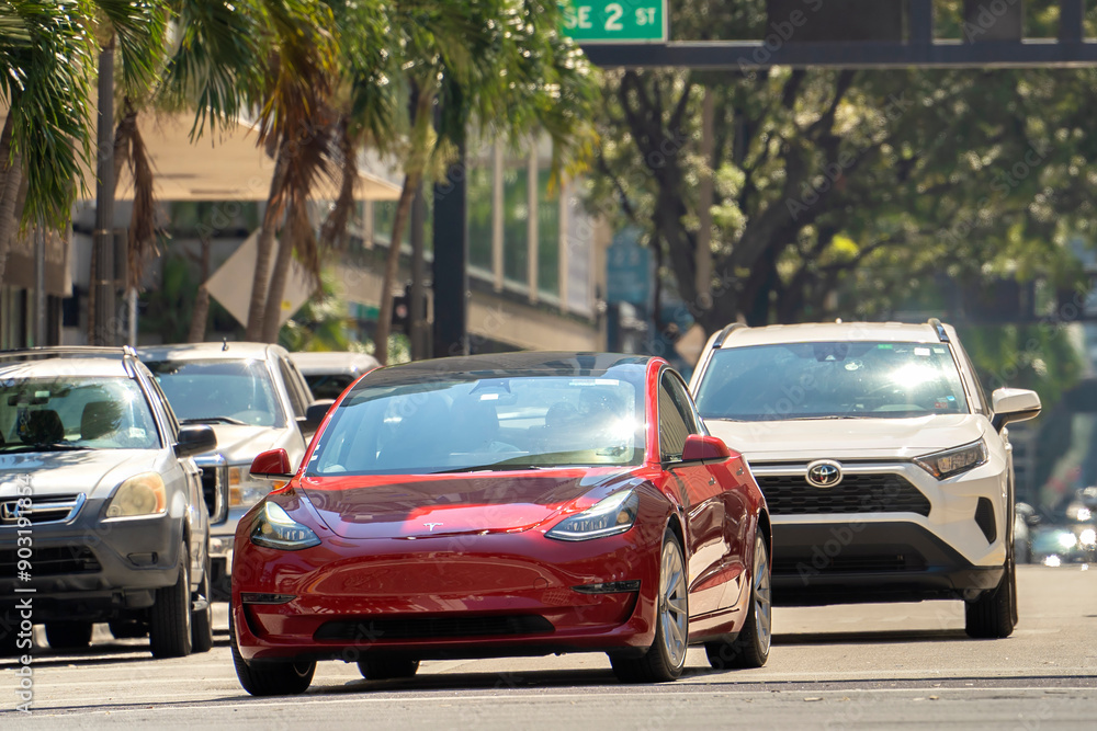 Tesla electric vehicle driving at intersection on American street with ...