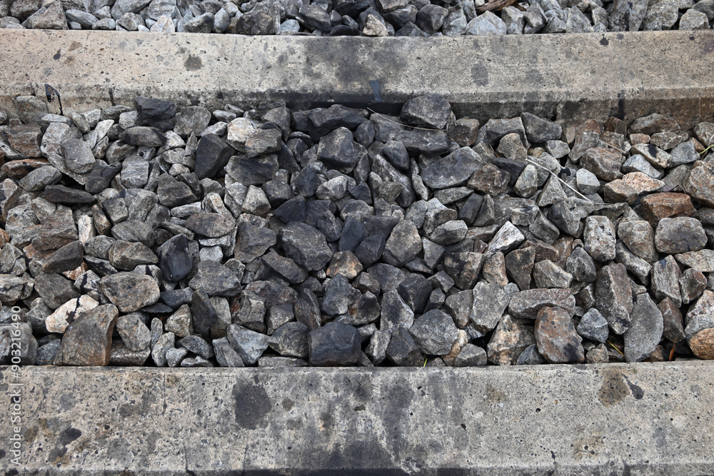 The stone track ballast is stacked on the gap between two sleepers in ...