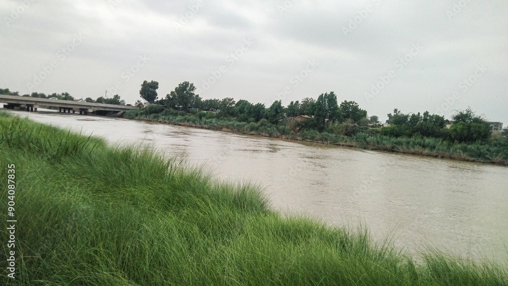 Water canal flowing with full of water with natural green grass on the ...