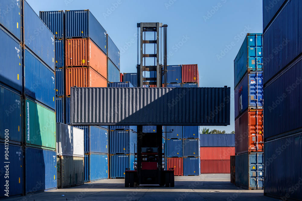 Forklift truck lifting container stack at containers yard for import ...
