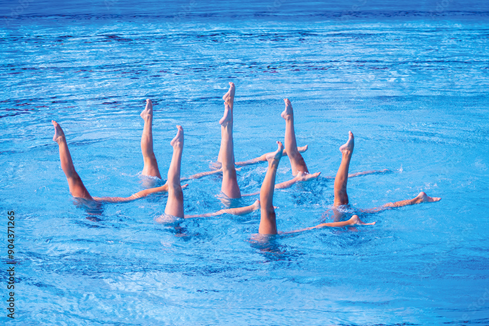 Synchronized female artistic swimming team performing synchronized legs ...