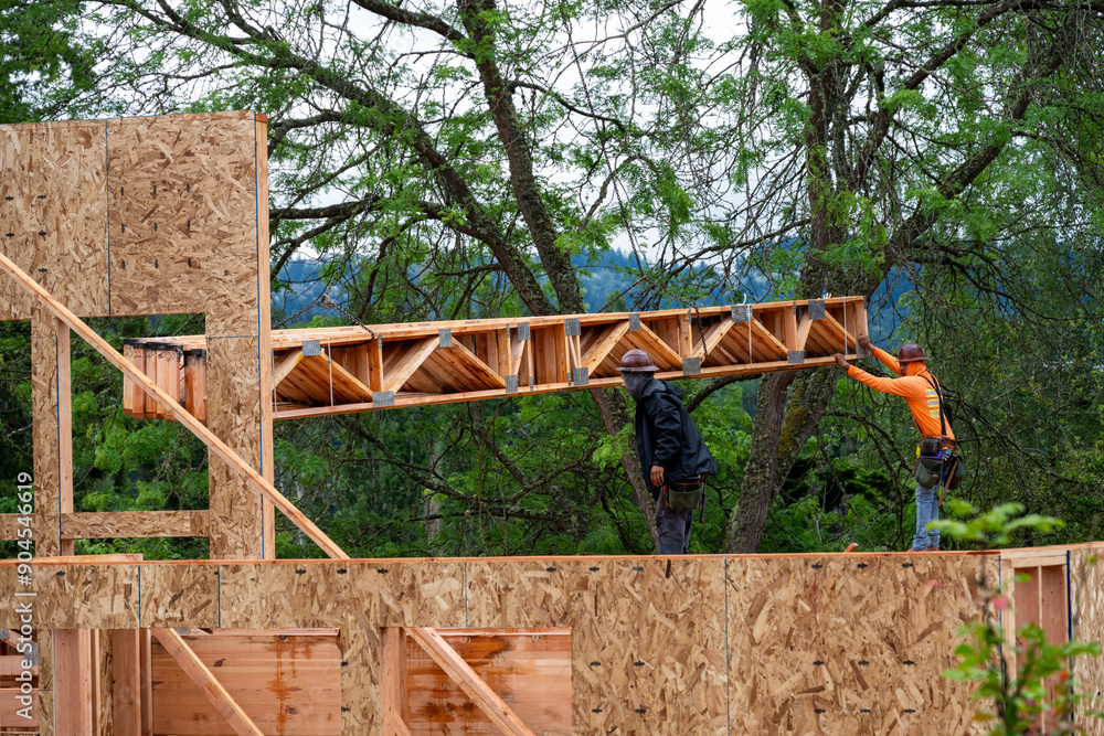 Residential house construction, boom crane lifting lumber delivery ...