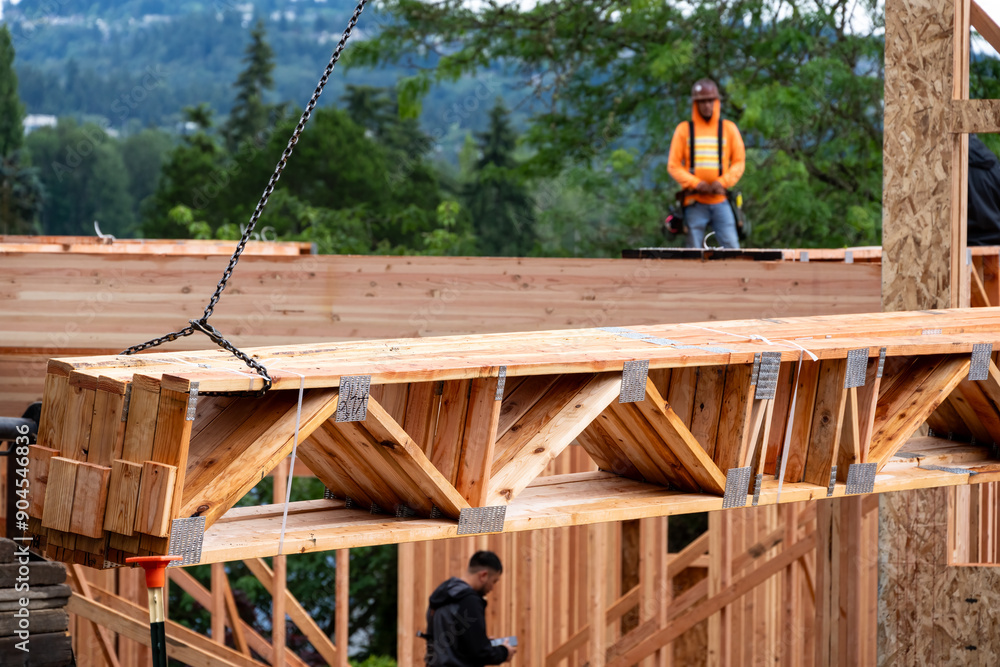 Residential house construction, boom crane lifting lumber delivery ...