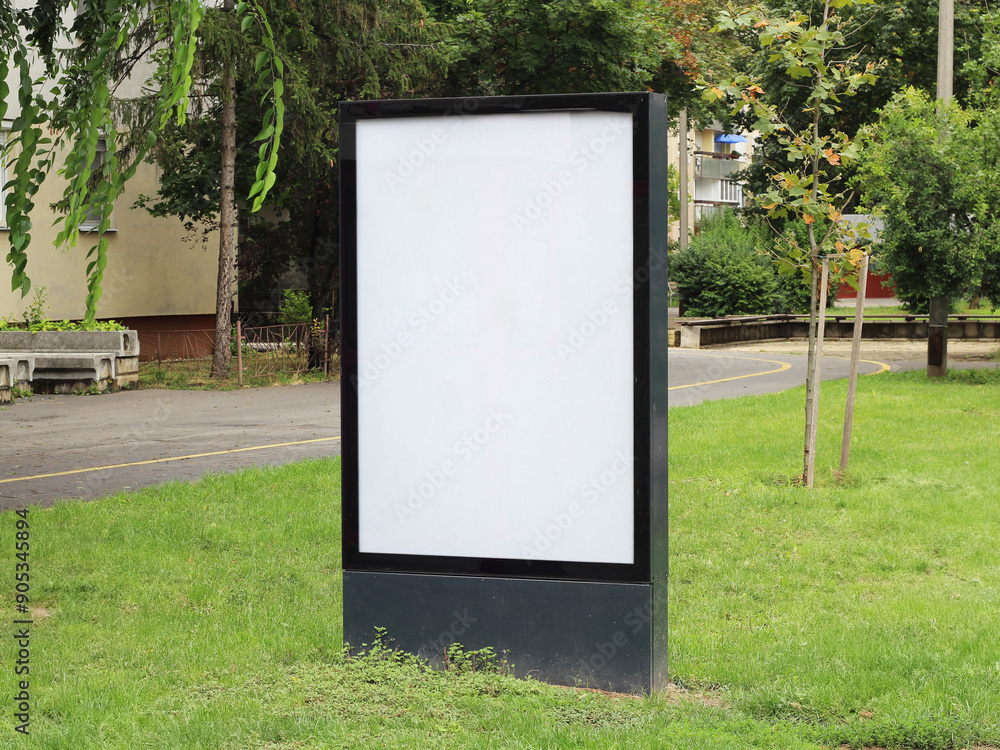 Blank advertising vertical street billboard poster in a green park ...