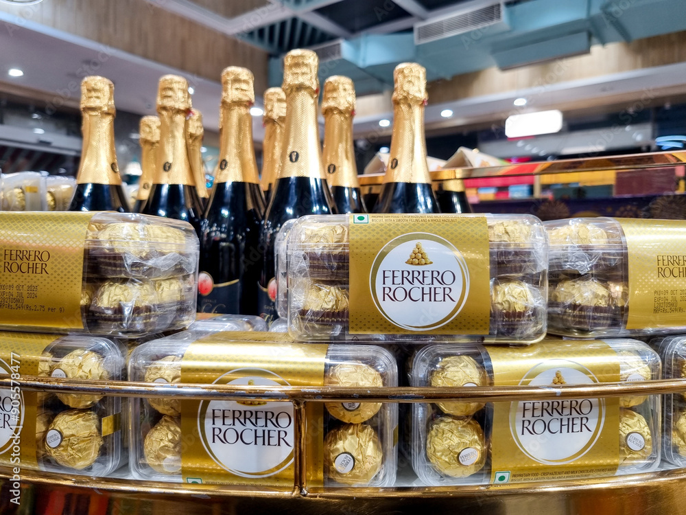 Boxes of famous Ferrero Rocher placed on a shelf with champagne bottles ...