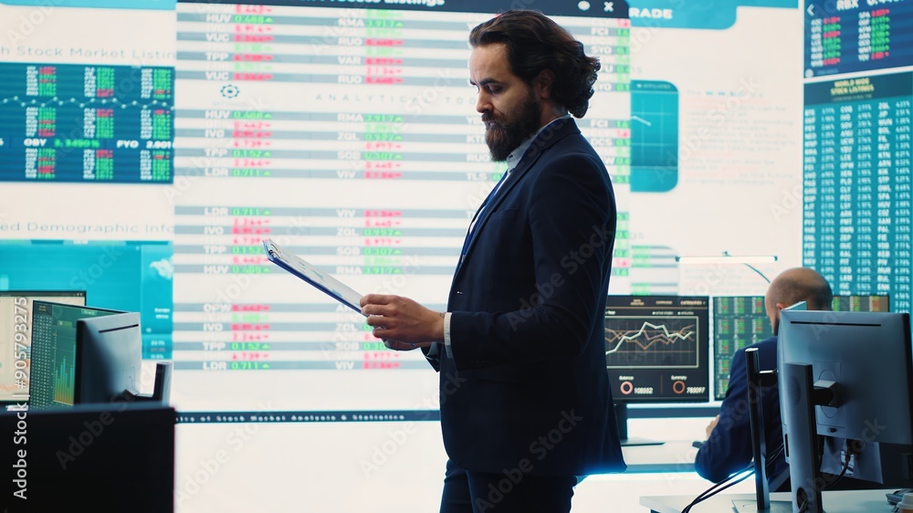 Chief executive officer reviews data shown on big display in the office ...