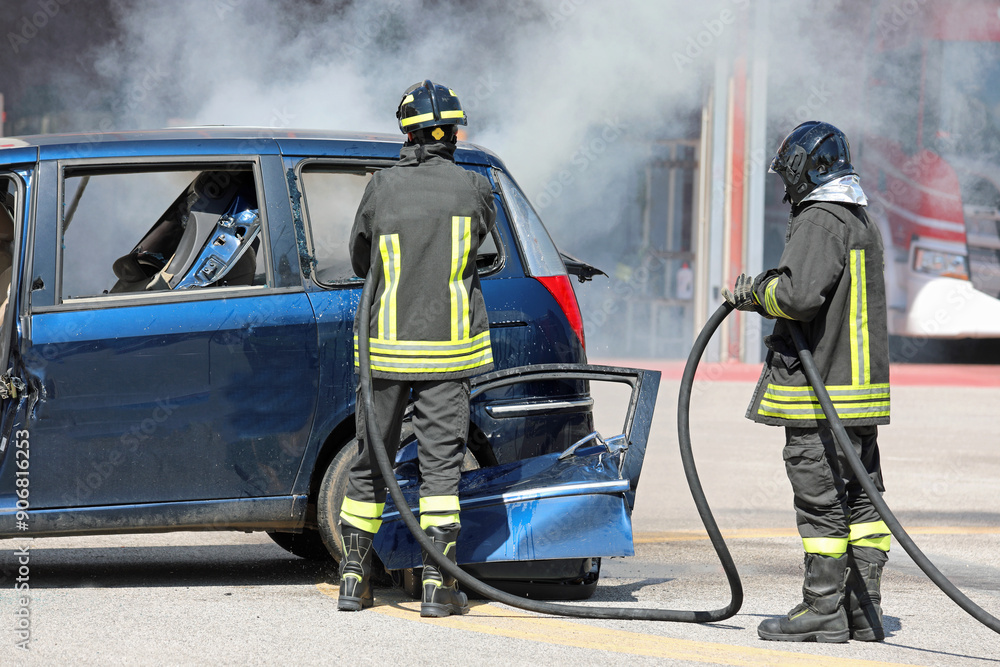 brave firefighters in uniform with helmets extinguish the fire of the ...