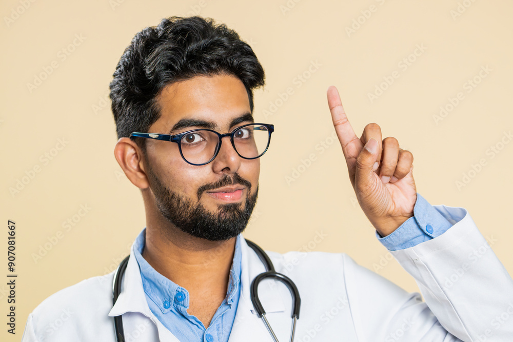 Eureka. Inspired Indian young doctor cardiologist man pointing finger ...