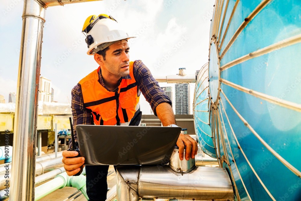 Male HAVC refrigeration system technician holds laptop recording ...