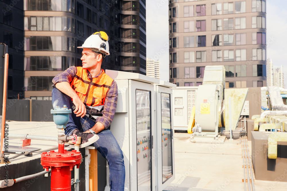 Male worker, AVC refrigeration system technician, works on the rooftop ...