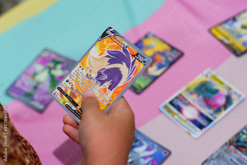 Hand of child holding pokemon cards. Indonesian youths playing these ...