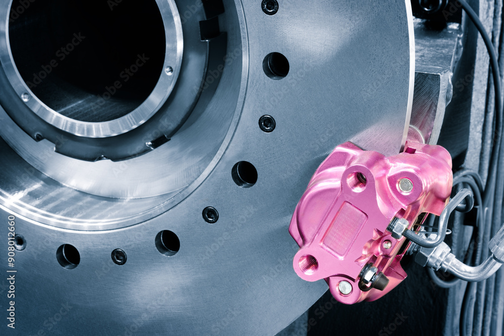 a metal disc with a pink brake on it. The brake is attached to a hose ...