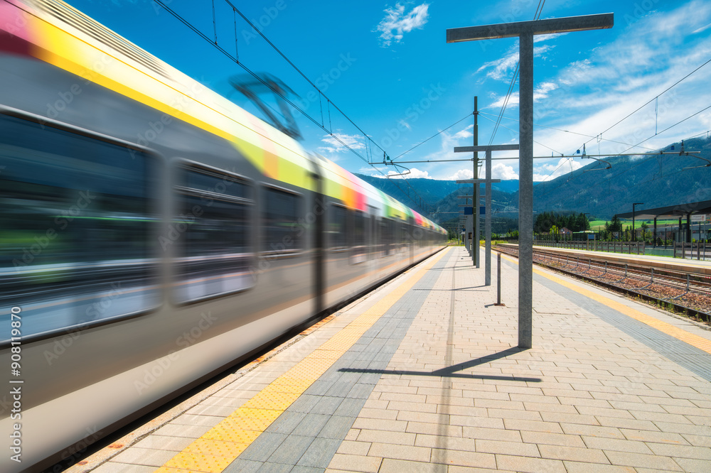 High-speed green passenger train moving at railway station platform at ...
