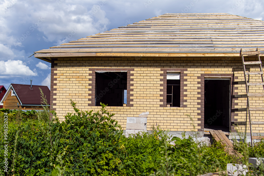 Unfinished country brick house. Wooden beams and roof rafters. House ...