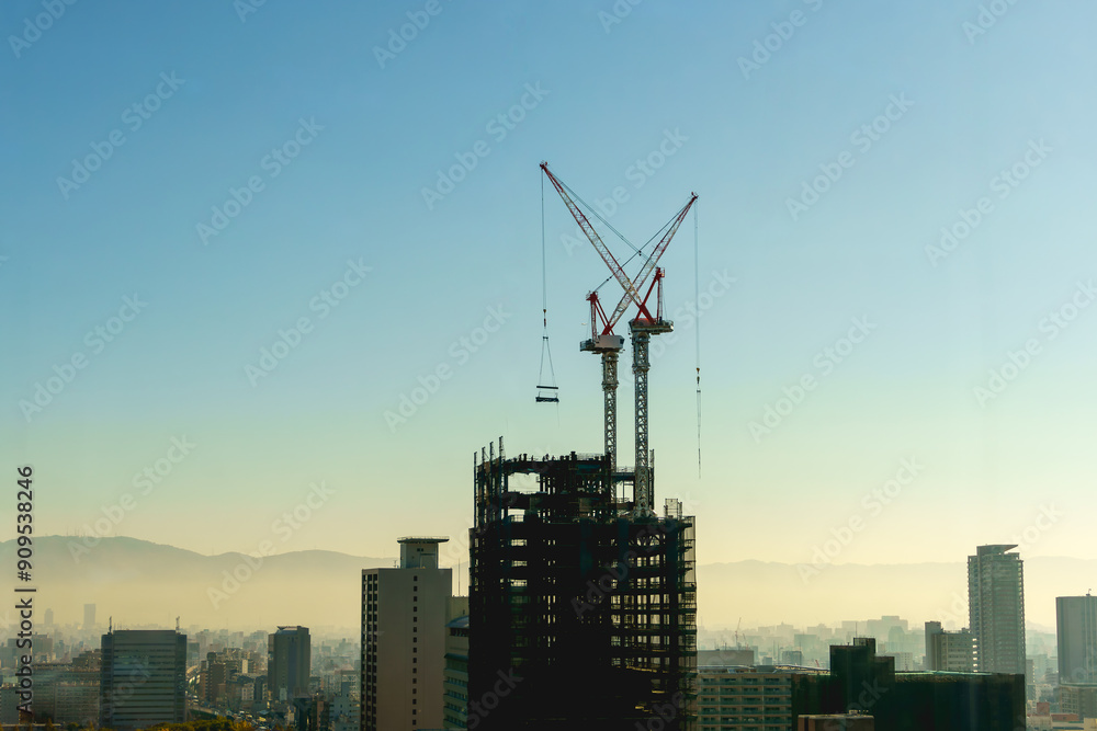 Construction site with cranes on the top of high buildings ...