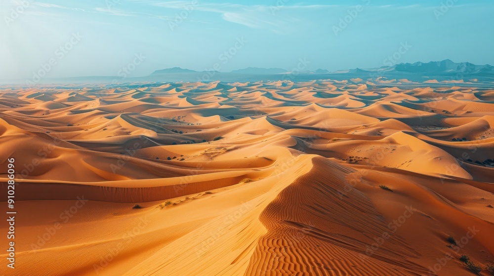 Aerial view of expansive desert sand dunes under a clear blue sky ...