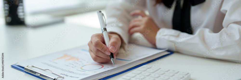 Asian female freelancer sitting and working with laptop doing paperwork ...