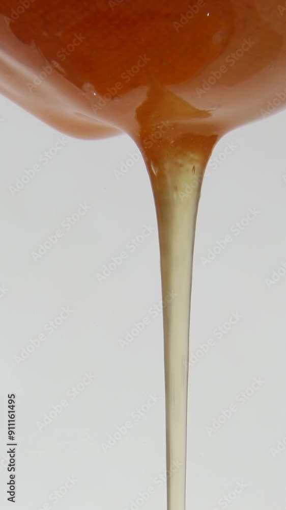 Continuous filtration process of fresh honey on a white background ...