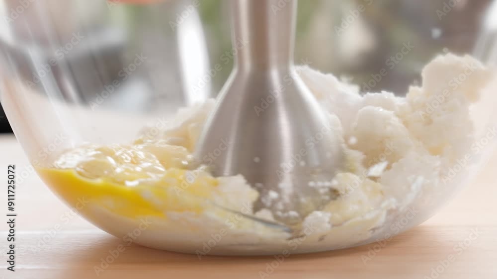 Macro. Cream cheese and eggs are chopped with an immersion blender in a ...