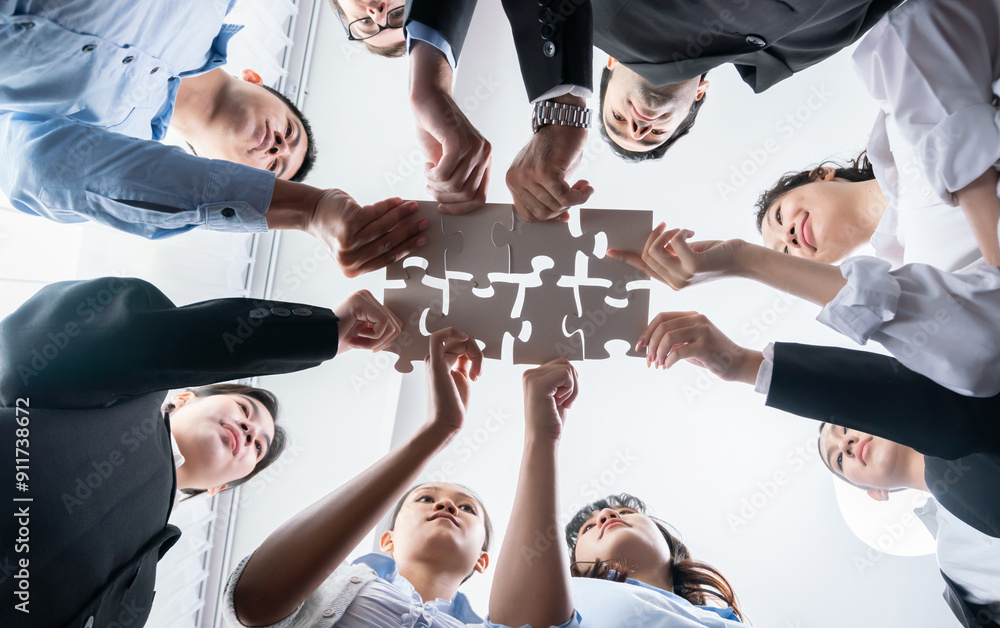 Multiethnic business people holding jigsaw pieces and merge them ...