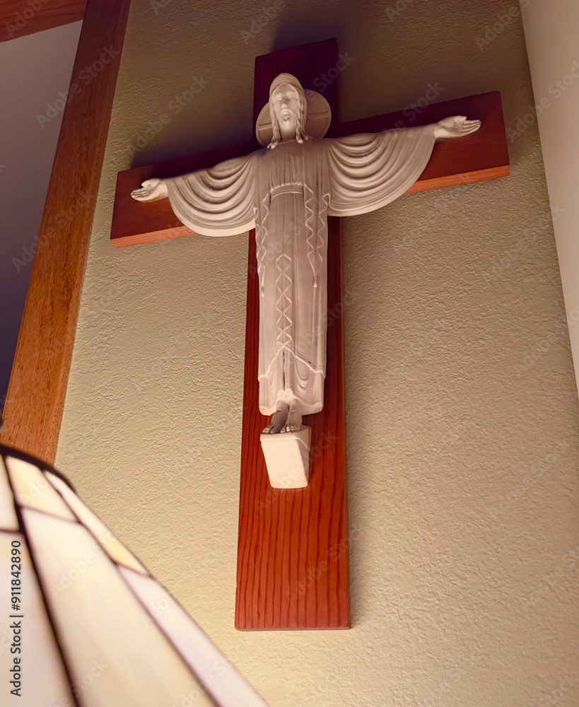 Jesus on the cross in sculpture against a plaster wall with wood ...