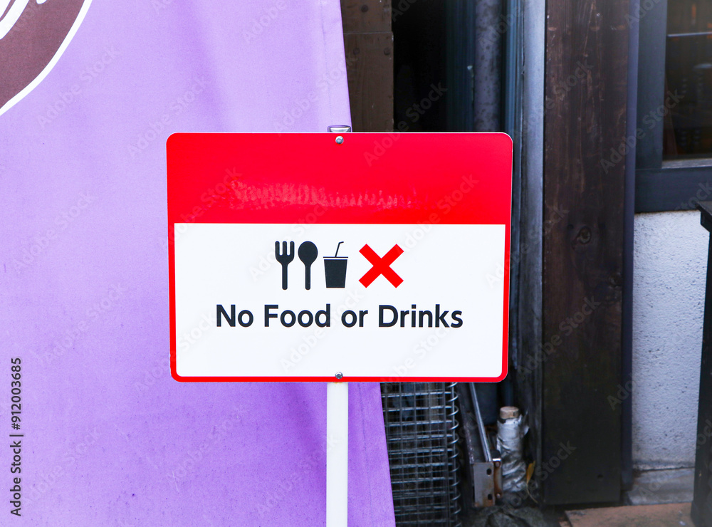 Square white plastic sign No Food or Drinks side street wall is ...