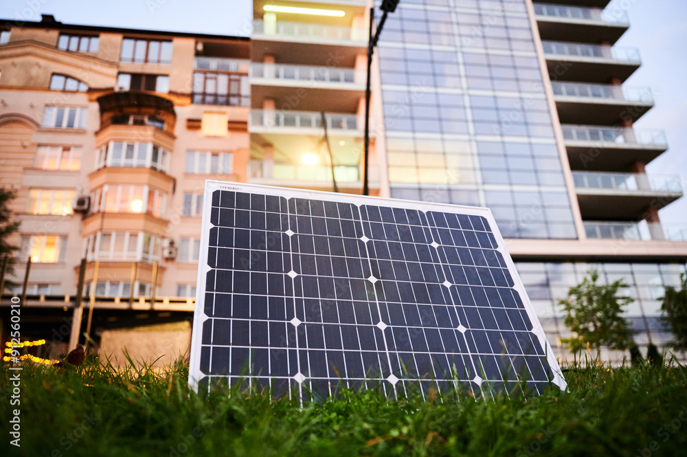 Photovoltaic solar panel in front of modern apartment building with ...