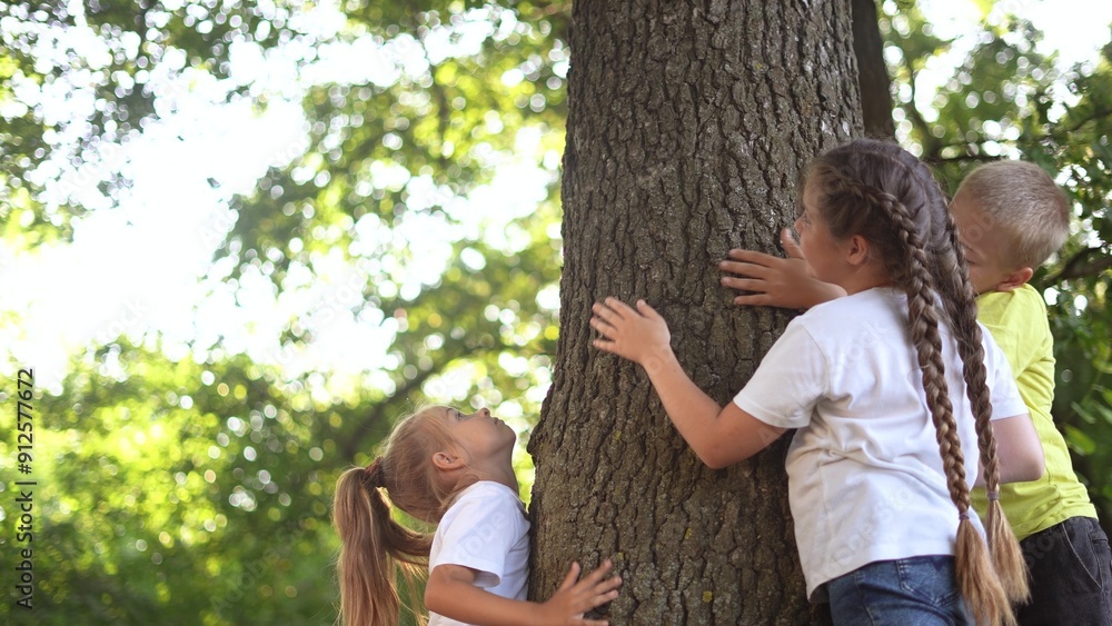 children hugging a tree in the forest. lifestyle happy family childhood ...