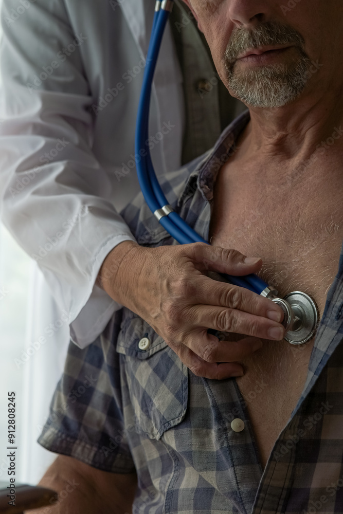 Physician, doctor examines a patients chest with a stethoscope at a ...