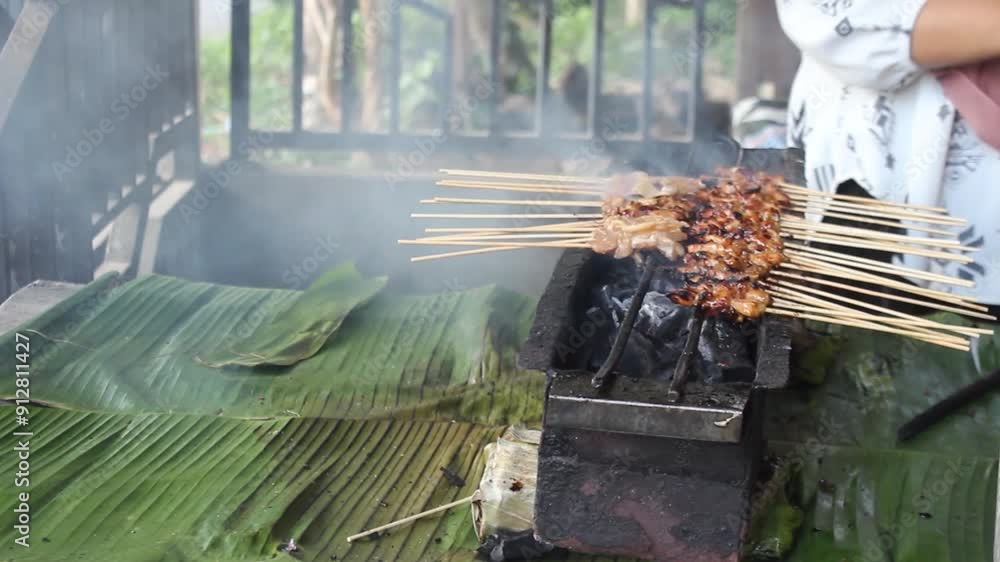 "Chicken satay grilled over traditional charcoal fire, showcasing ...