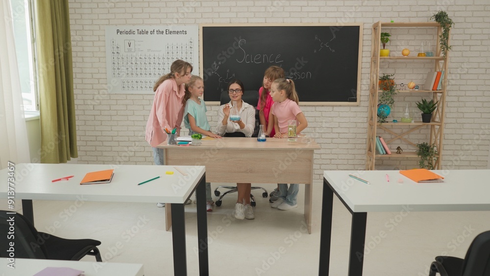 Junior school children sit in classroom on science chemistry lesson ...