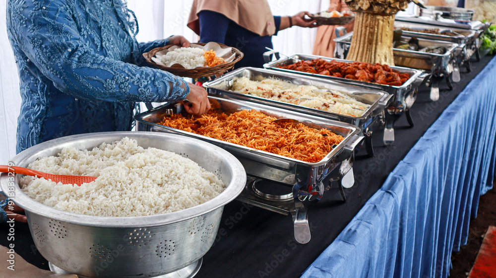 A buffet table with various dishes, including rice, noodles, and meat ...