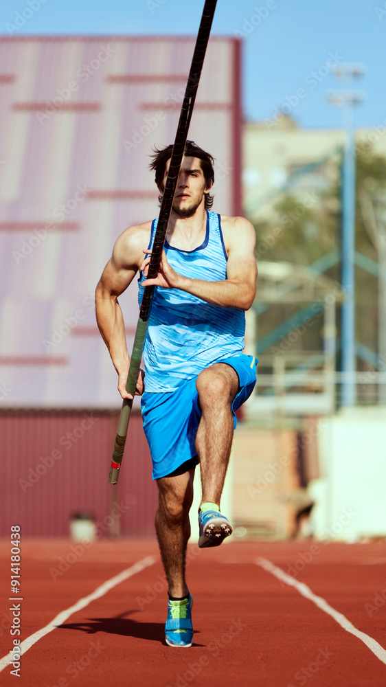 Pole jump athlete, young focused man in blue uniform on stadium track ...