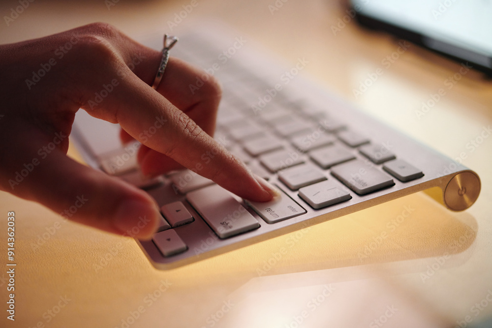 Close-up of a hand typing on modern white keyboard on an office desk ...