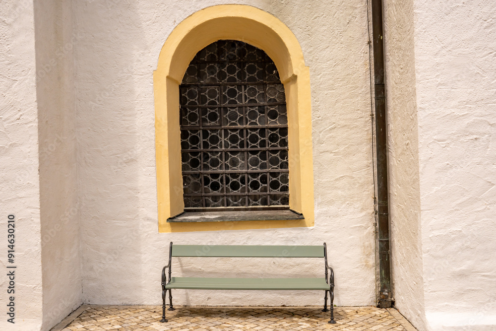 Painted park bench with curved cast iron bench feet in front of ...