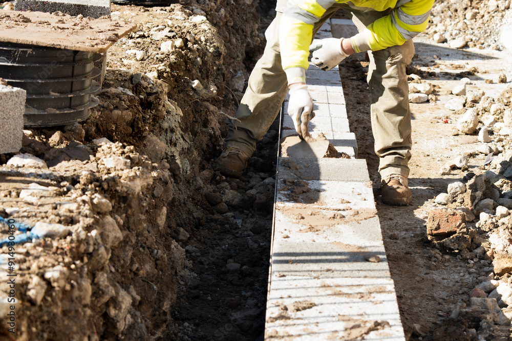 Construction Worker Laying Concrete Blocks in Trench During Daylight ...