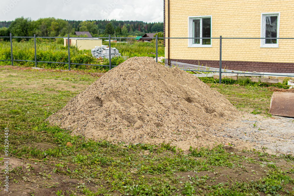 Pile of sand and gravel mixture on land plot. Material for land works ...