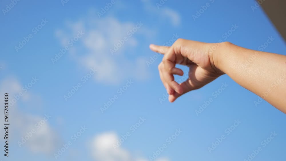 A Hand Pointing Toward a Clear, Beautiful Blue Sky with Fluffy White ...