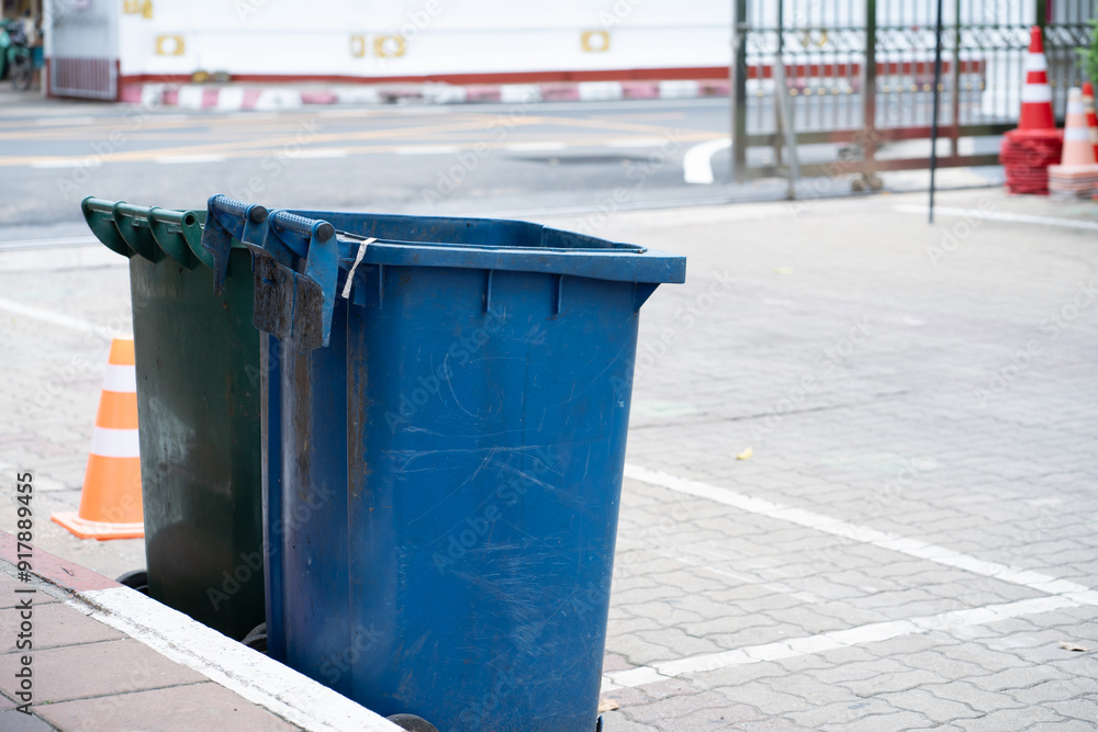 Green and blue trash cans are placed on the side of the road. Stock ...