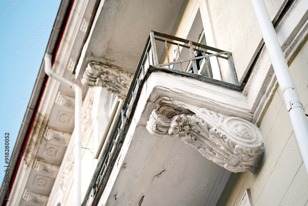 Damaged balcony with cracked plaster corbel, damaged concrete and ...