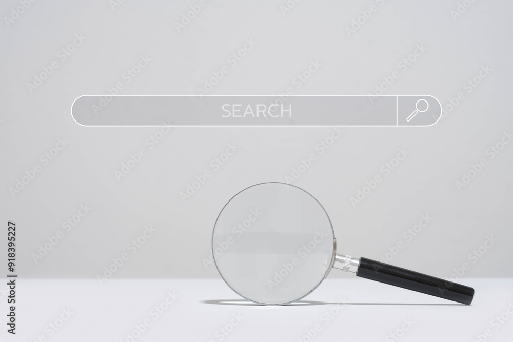 Magnifying glass below a search bar on a plain background, representing ...
