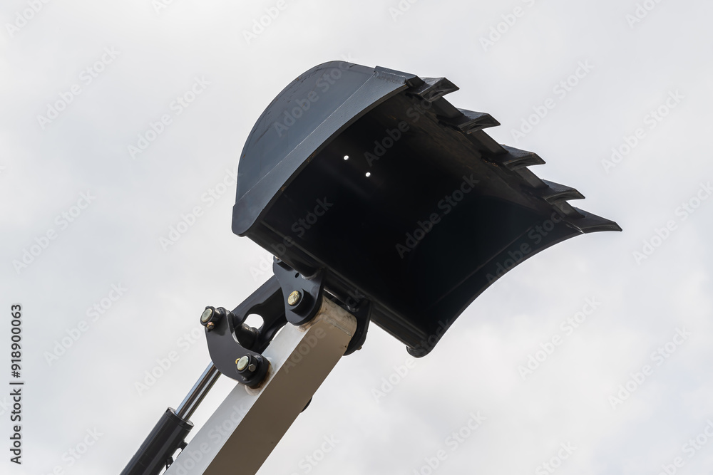 Black metal excavator bucket, part of heavy construction machinery ...