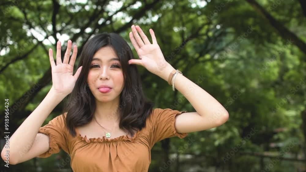 A young asian woman teasing someone by sticking out her tongue ...