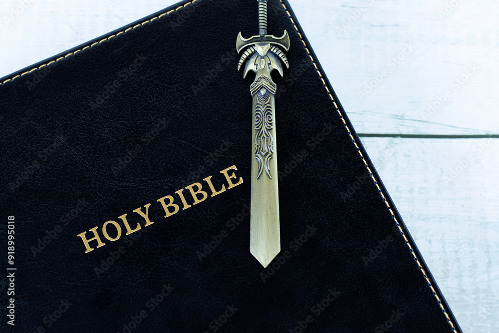 Ancient sword on top of Christian holy bible book. Top view. Close-up ...